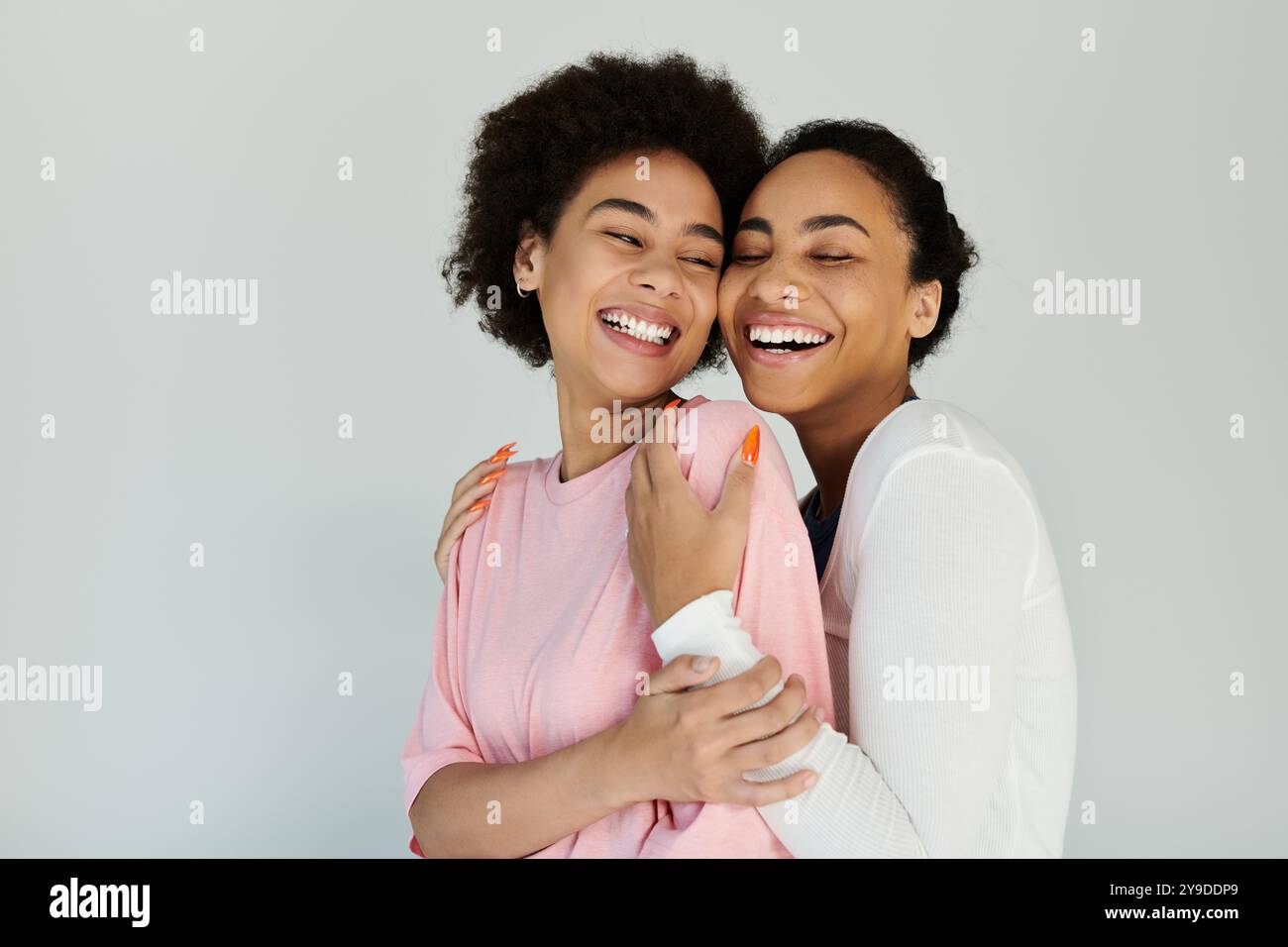 Two friends share a warm embrace while laughing, showcasing their ...