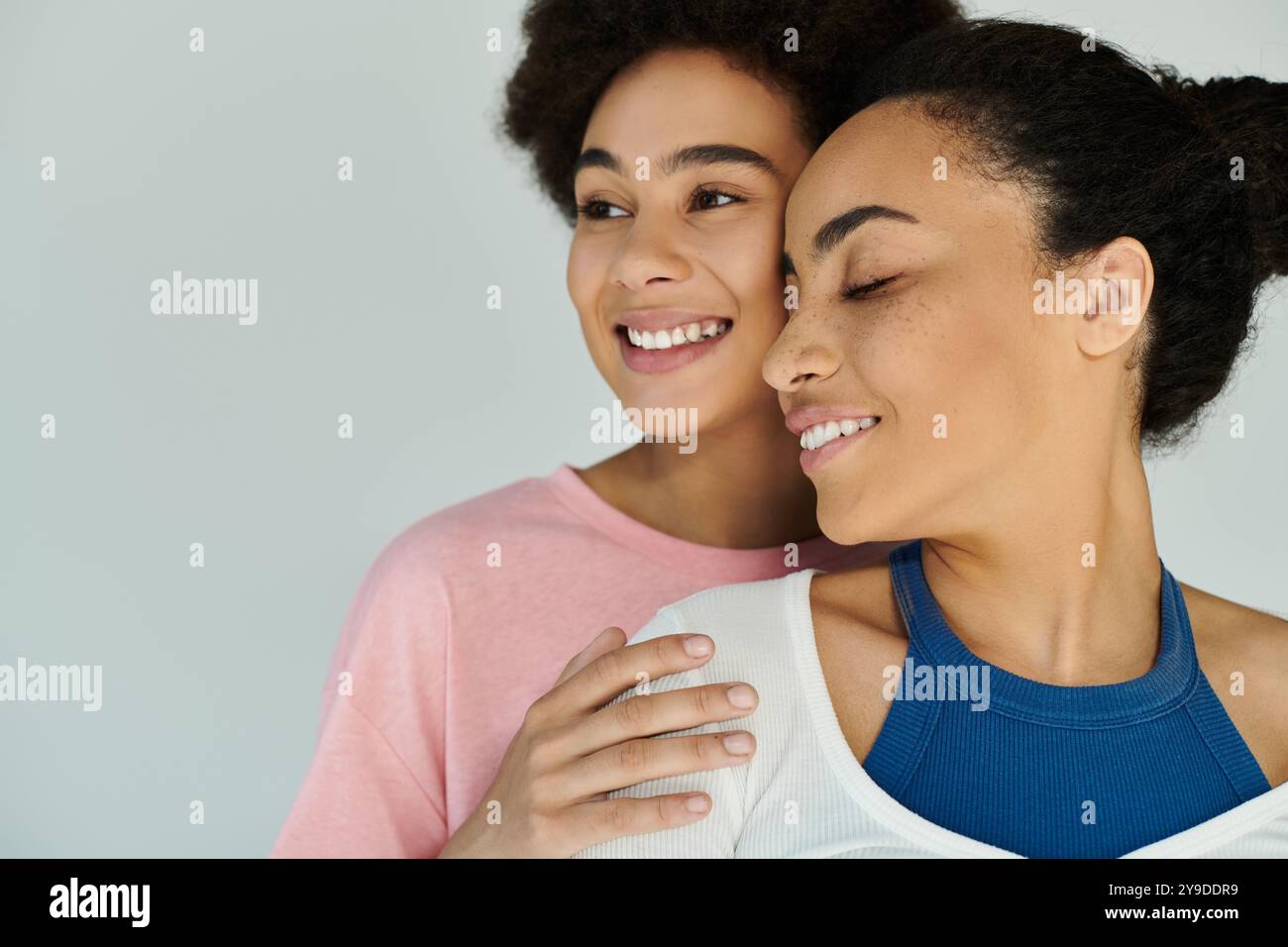 Two friends share a warm, affectionate moment, smiling and enjoying ...