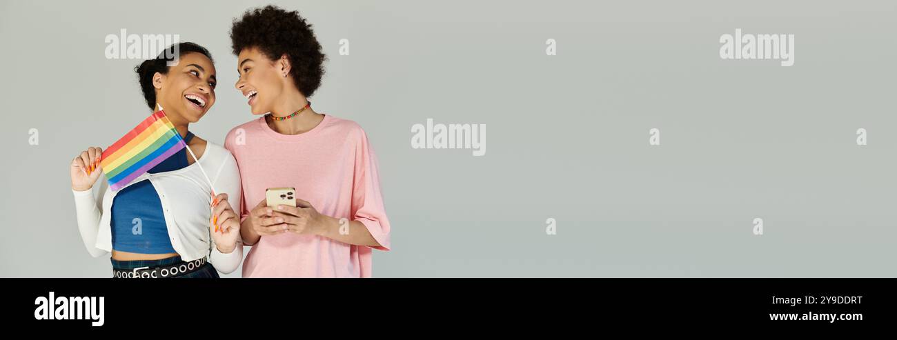 Two friends share laughter and joy while proudly displaying a rainbow ...