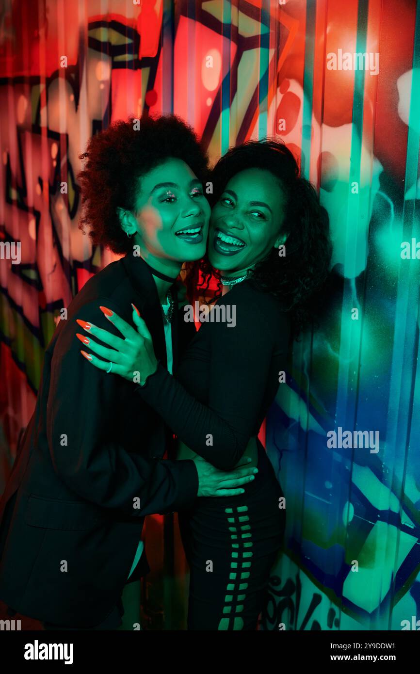 Two friends share a joyful moment, embracing each other amid colorful ...