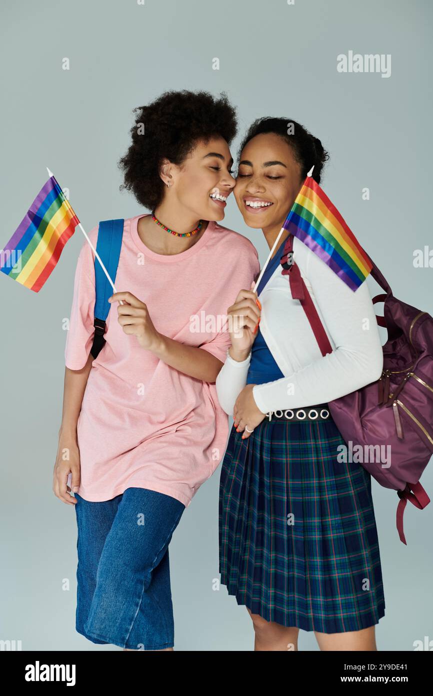 Two smiling friends share a moment of happiness while holding rainbow ...