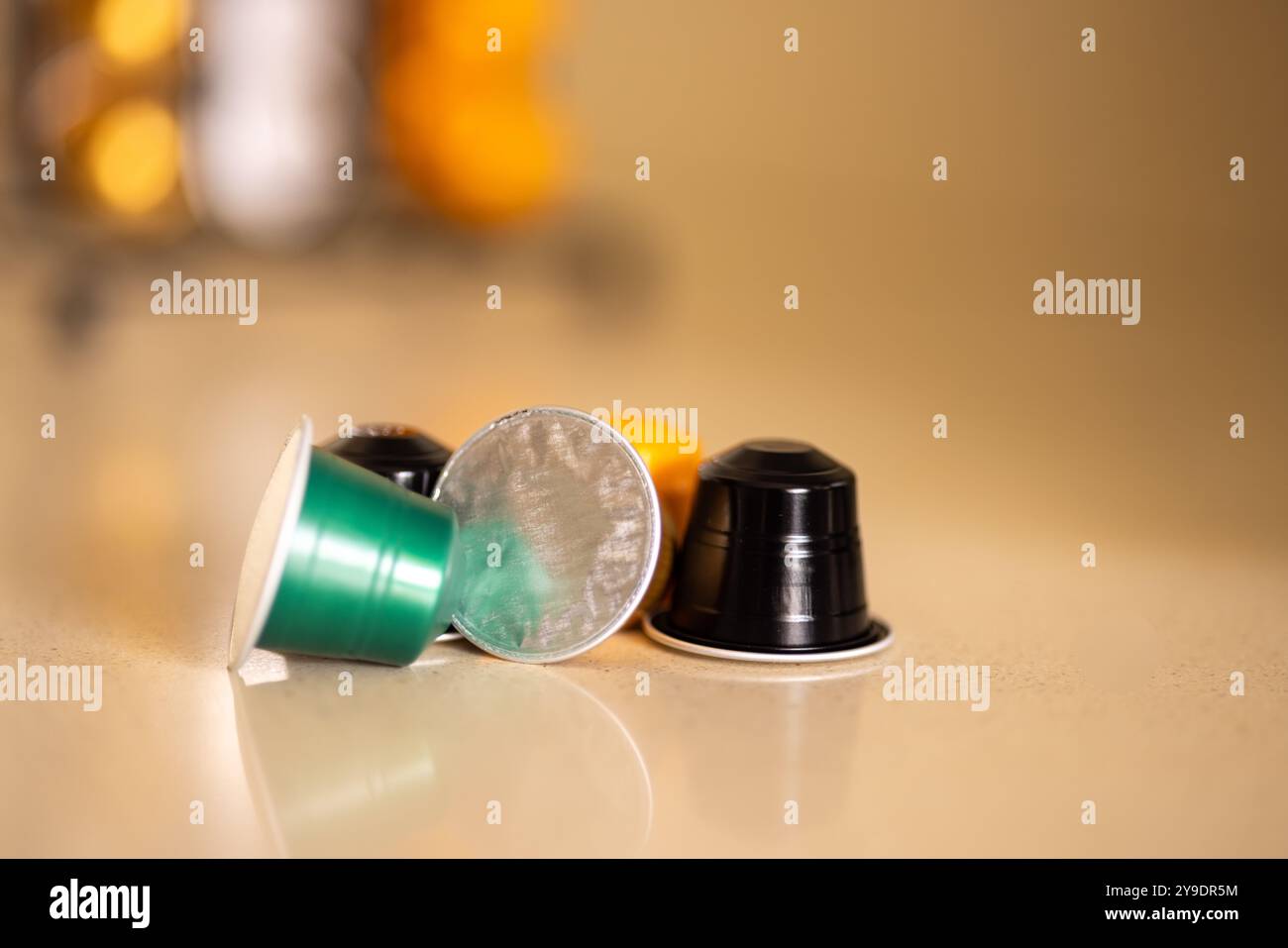 Coffee capsules in various colors displayed in front of a sleek capsule ...