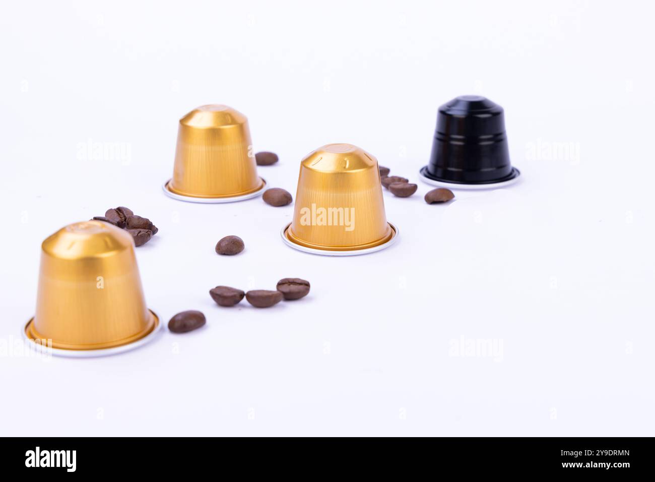 An appealing arrangement of golden and black coffee capsules alongside ...