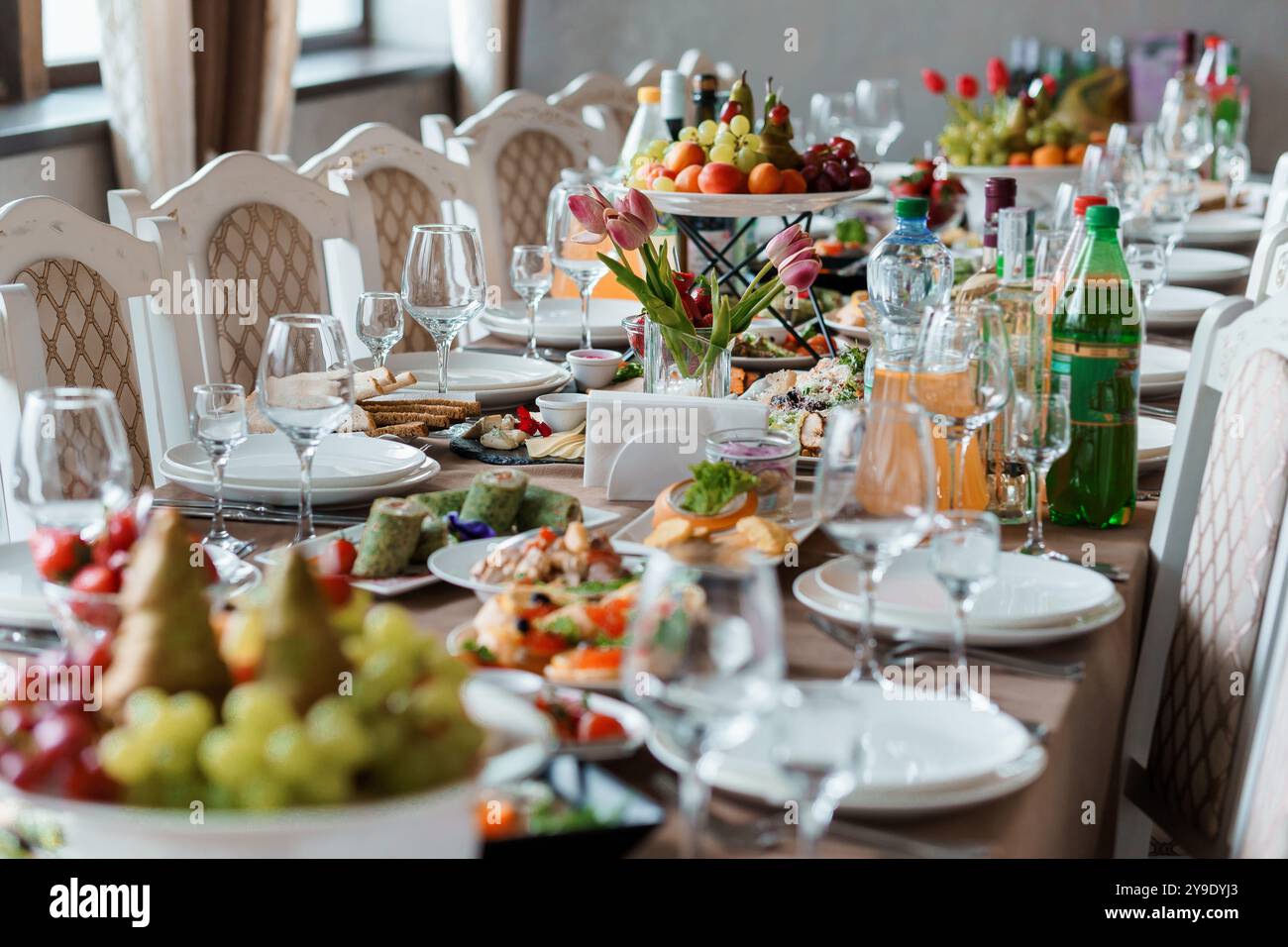 Elegant Banquet Table Set with Assorted Dishes and Fresh Fruits in a Chic Dining Setting Stock ...