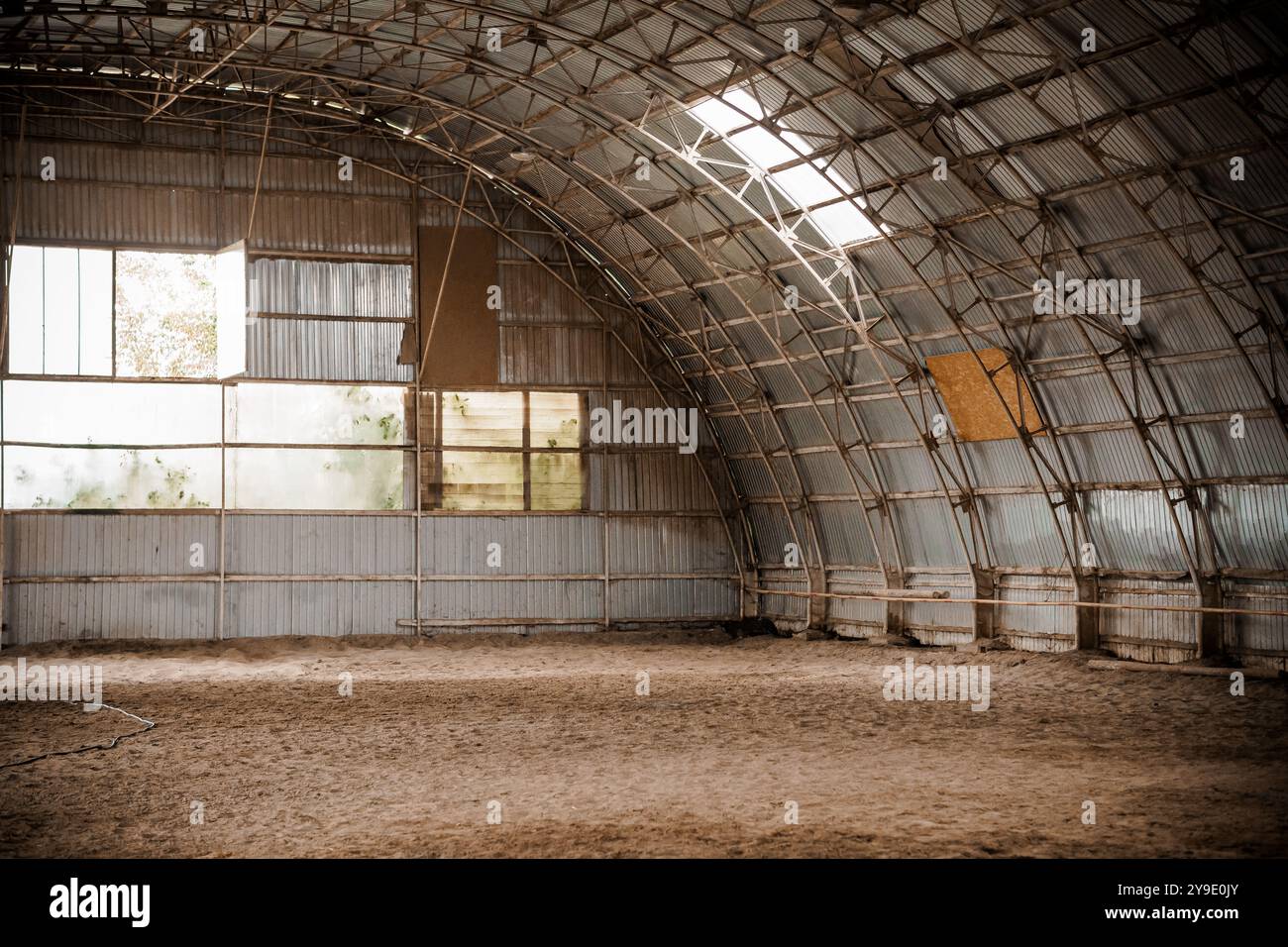 Rustic Indoor Arena with Natural Light Streaming Through High Windows ...