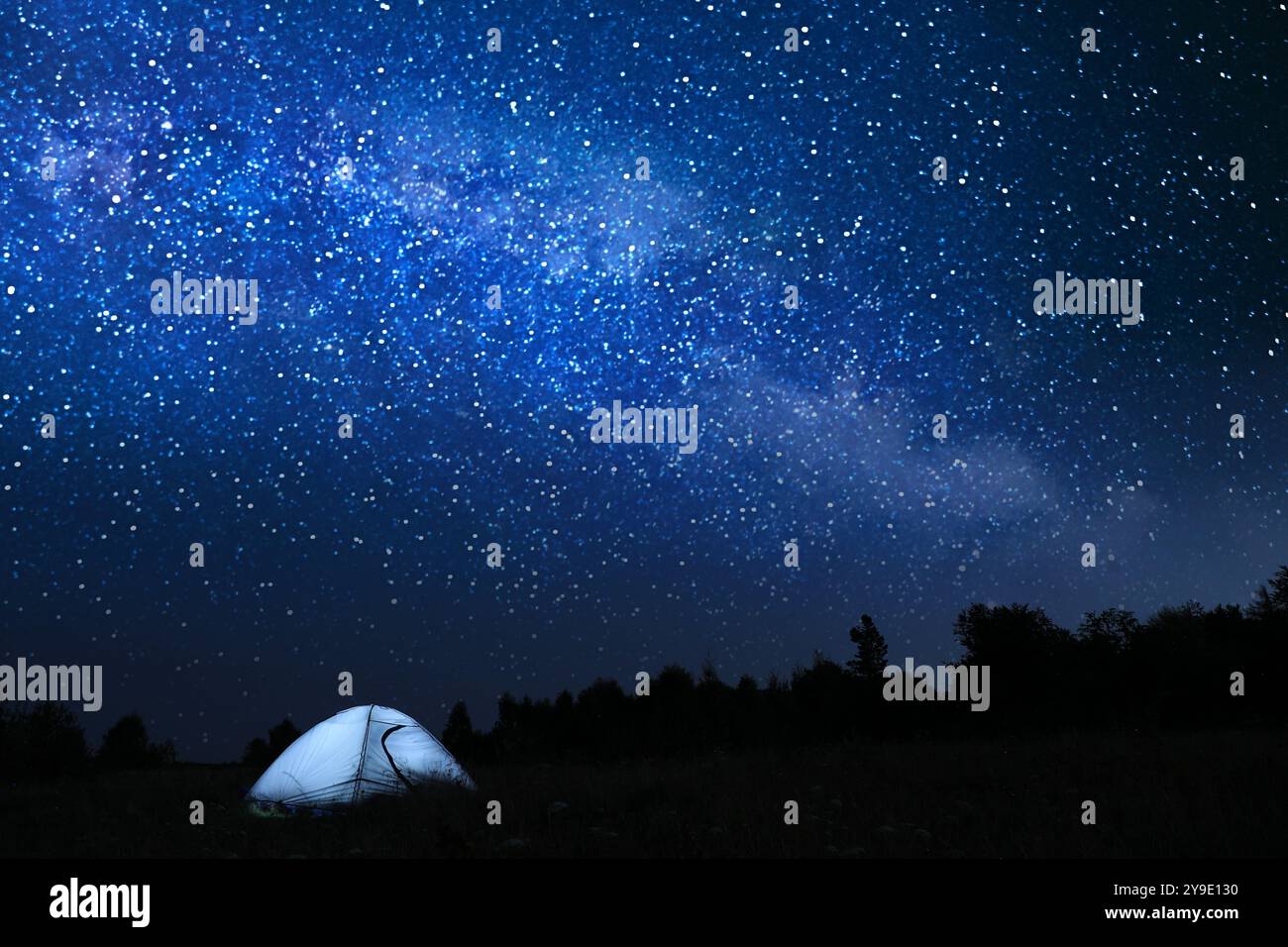 Modern camping tent in wilderness at night, slow shutter speed effect ...
