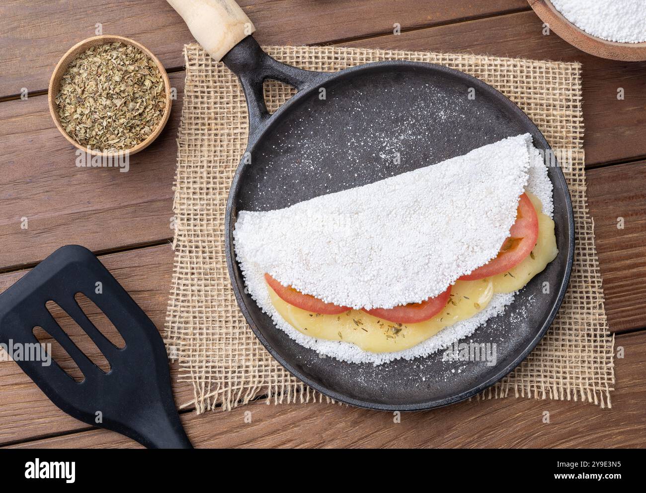 Traditional brazilian cheese and tomato stuffed tapioca on a pan with ...