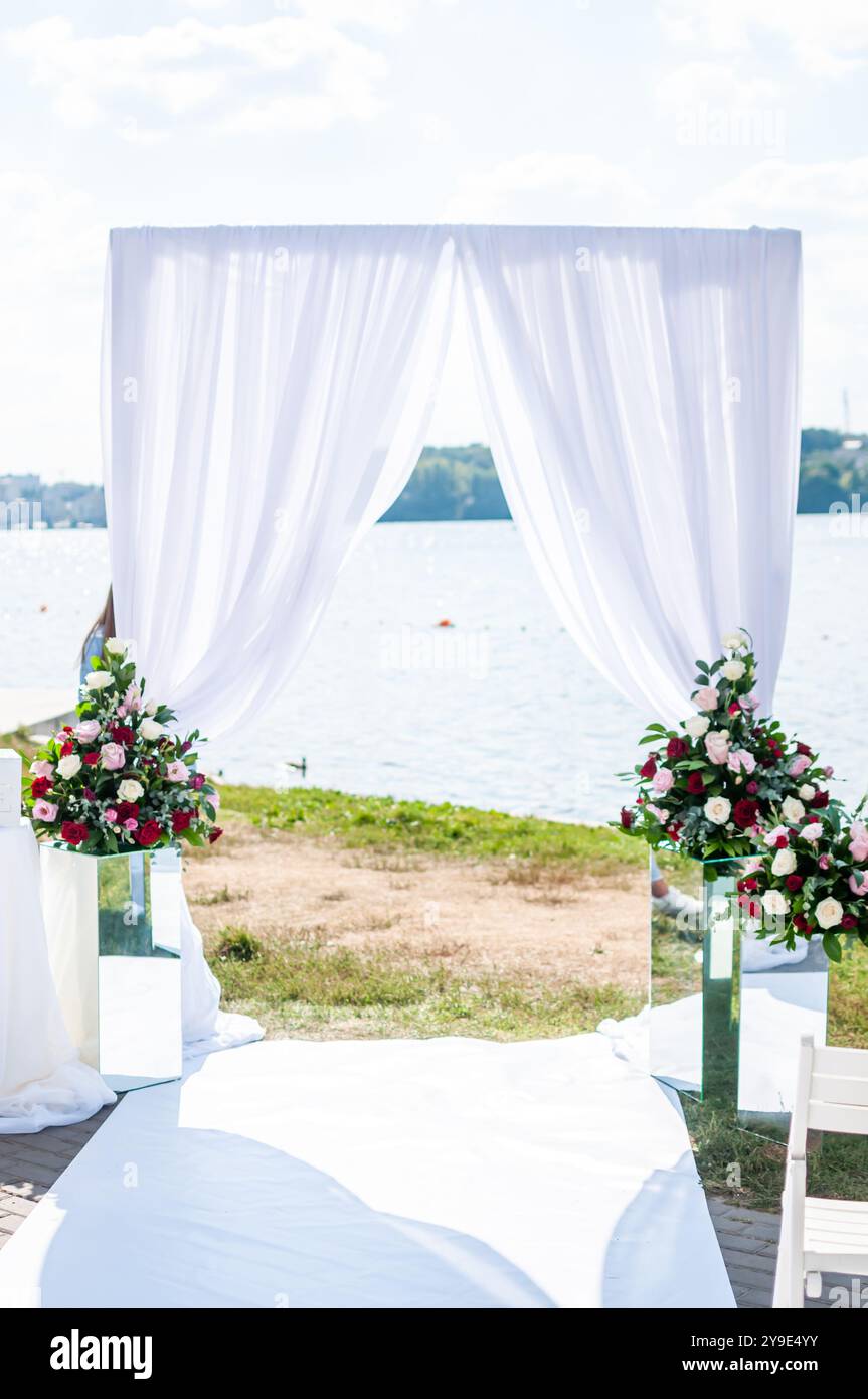 Elegant Outdoor Wedding Setup by the Water with Floral Arrangements and ...
