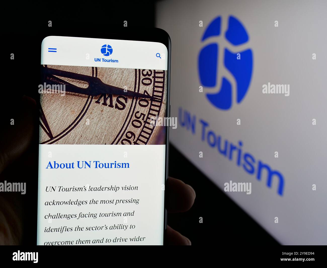 Person holding cellphone with web page of United Nations agency UN ...