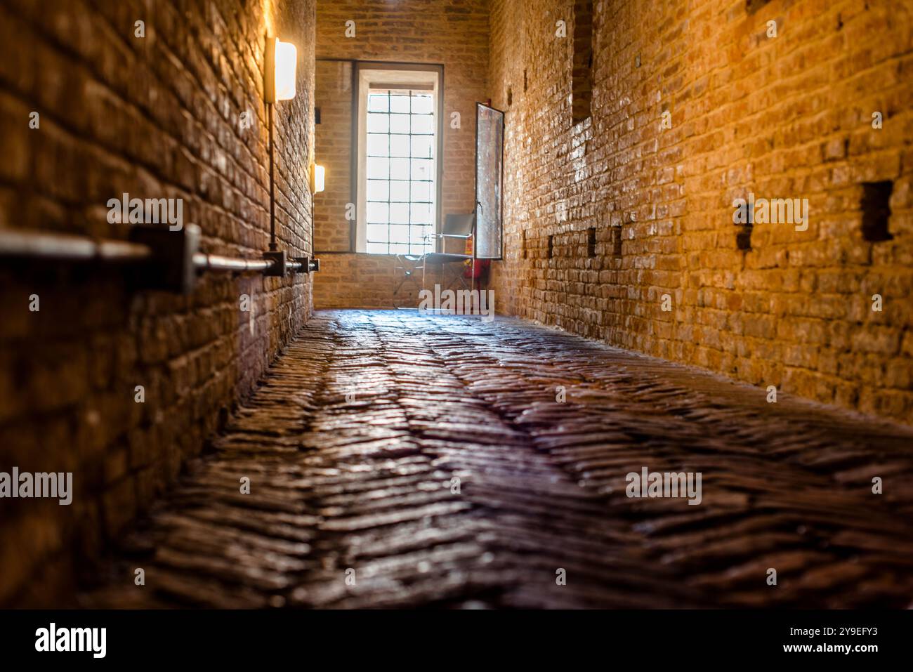 long brick corridor of an ancient building with window in the ...
