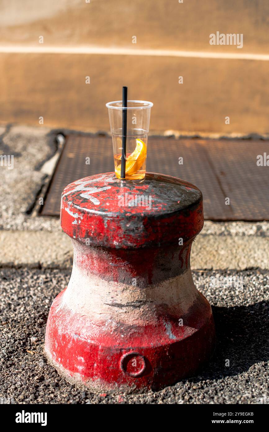 Abandoned plastic cup with black straw on top of a traffic bollard with ...