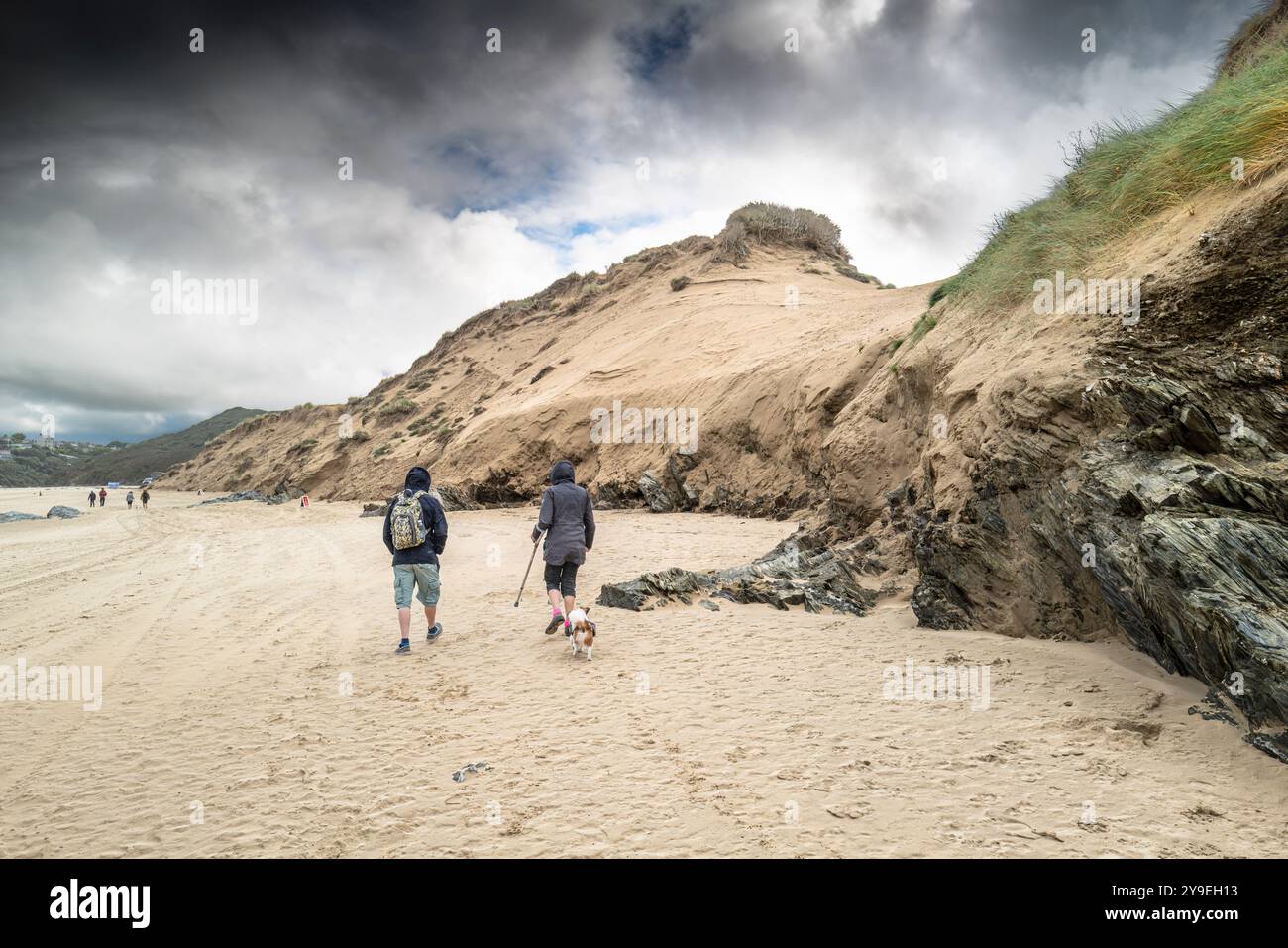 People walking past the unstable sand dune system on Crantock beach in ...