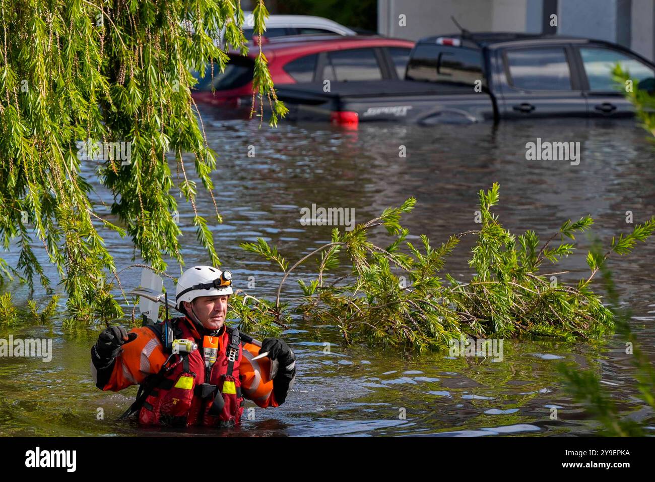 A water rescue team member walks through flood waters at an apartment ...