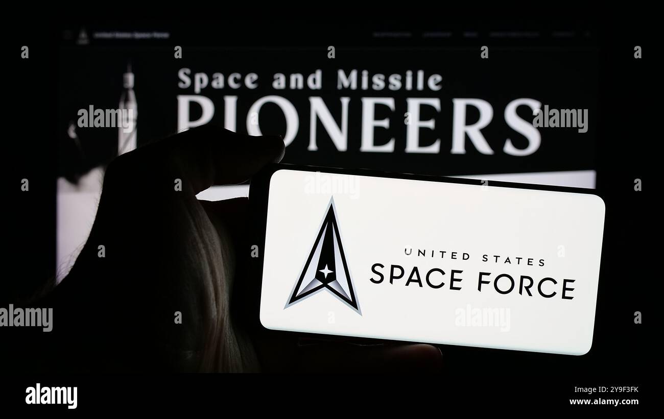 Person holding mobile phone with logo of United States Space Force ...