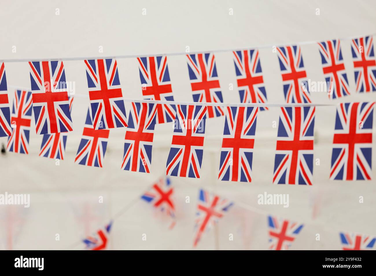 Strings of Union Jack flags hanging in marquee to celebrate an event ...