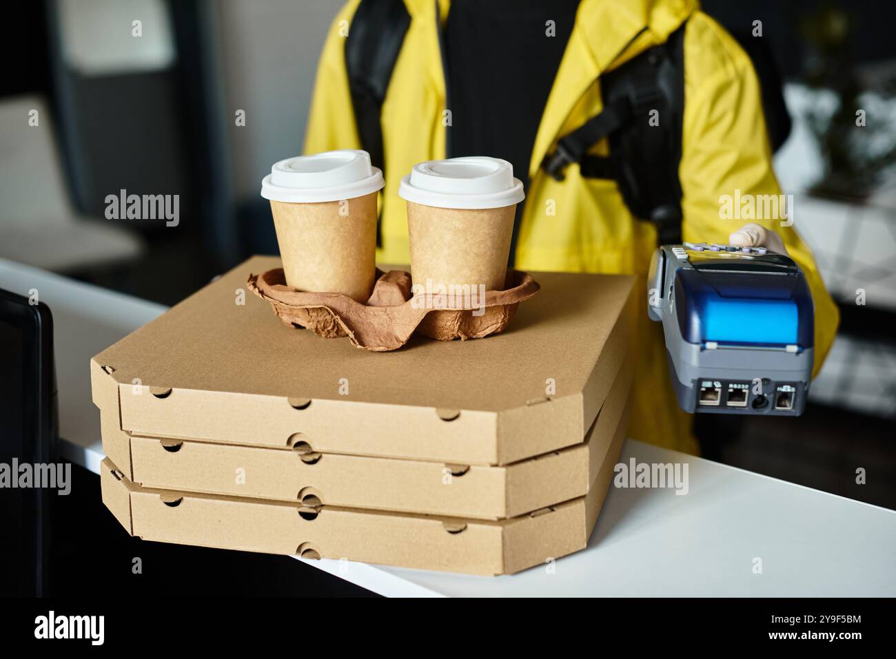 A delivery worker brings pizza and coffee to an office, ensuring a ...
