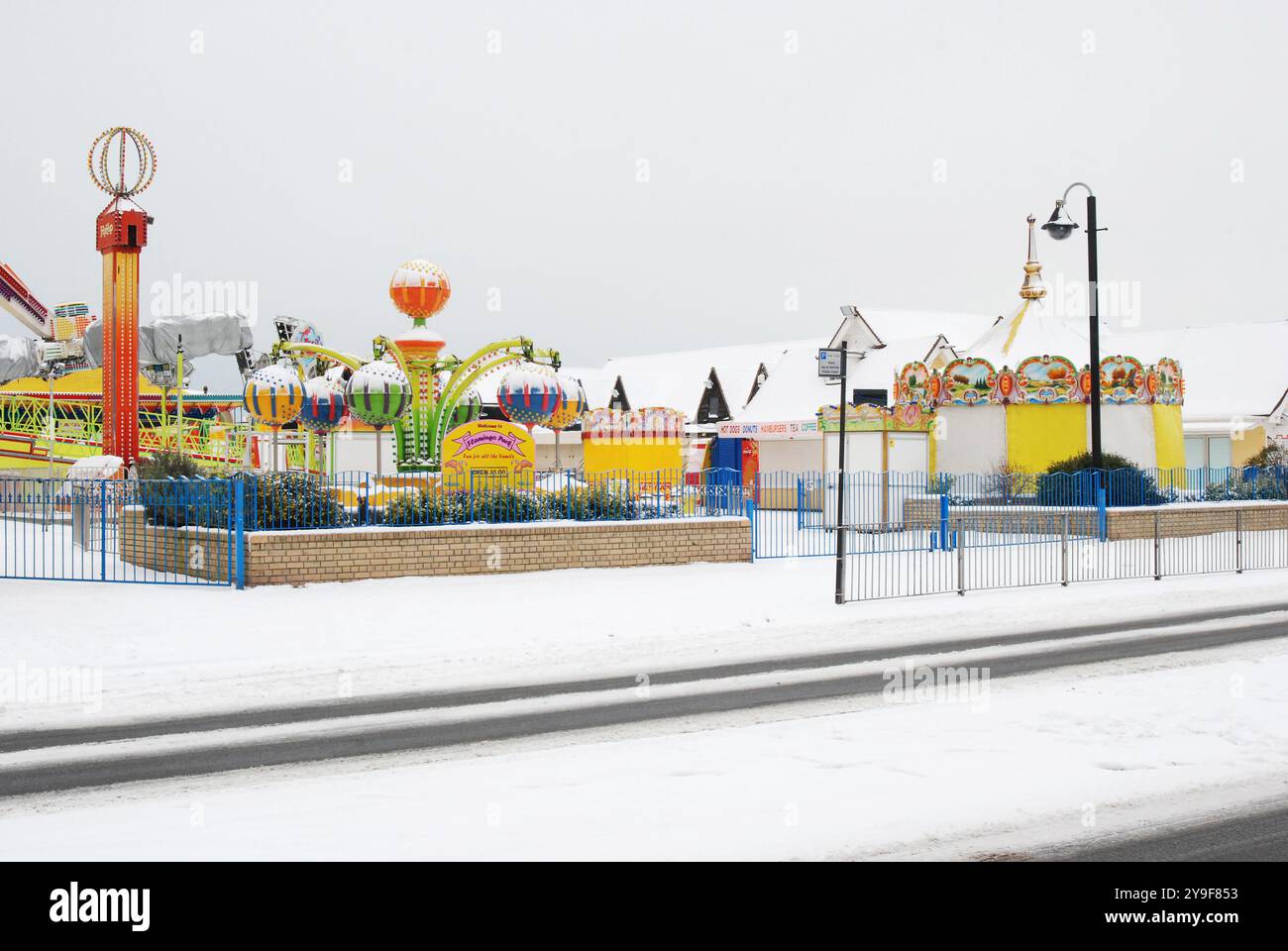 A serene winter scene at a snow-covered Hastings fairground, with ...