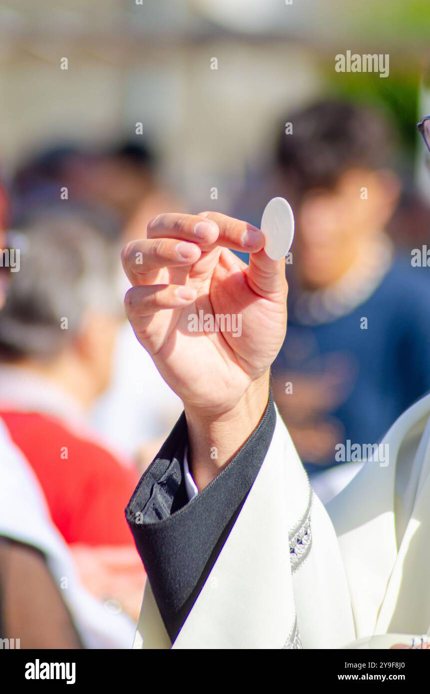 hand of a catholic priest elevating the host in the sacrament of ...