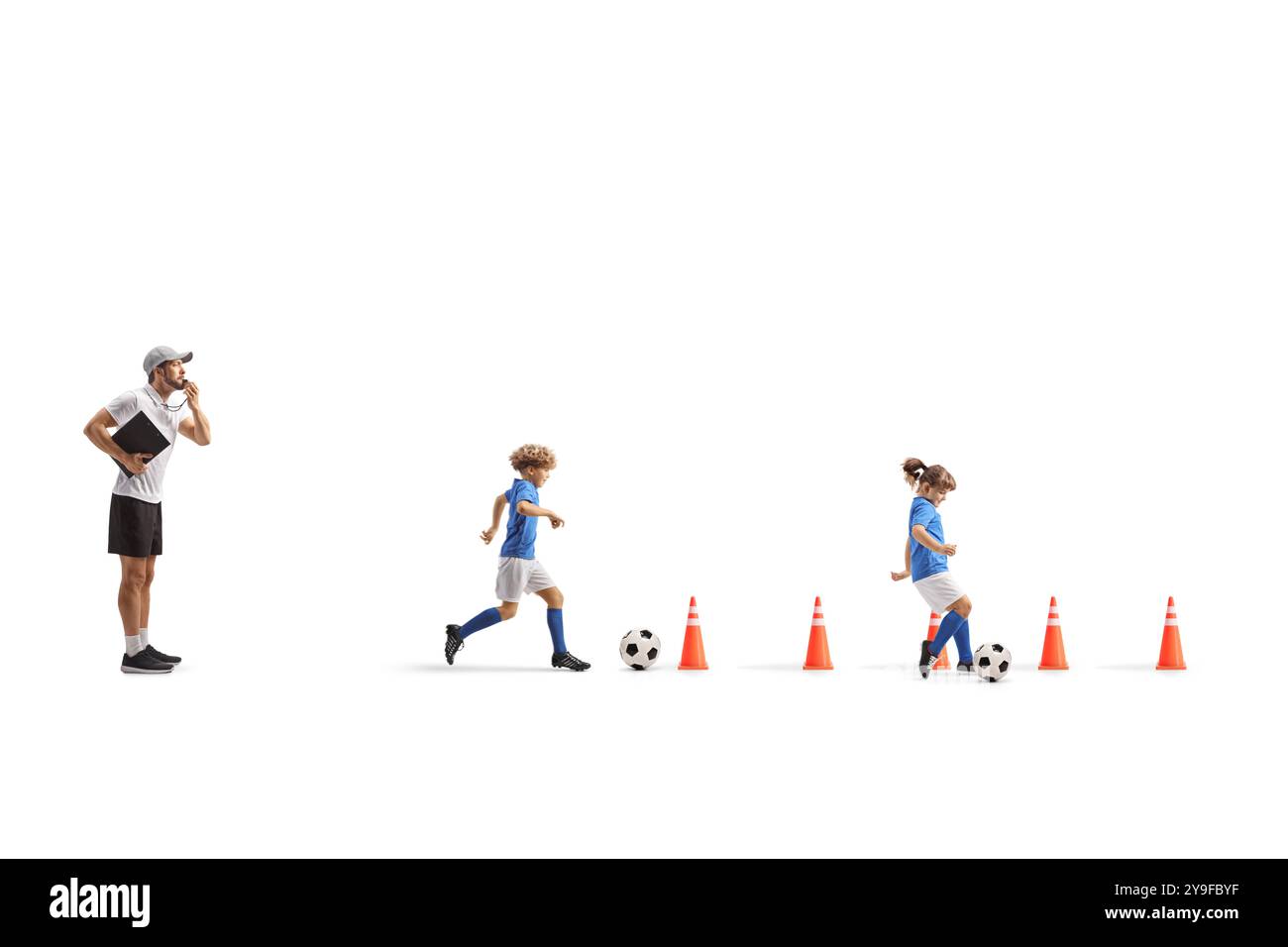 Coach training a boy and girl to lead a football between obstacle cones ...