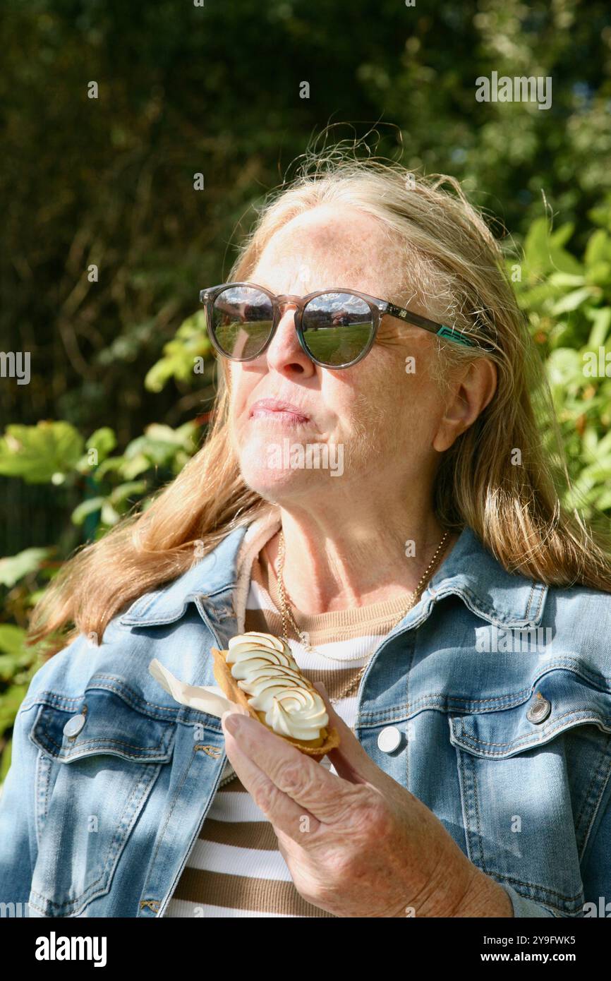 A pretty lady eating a lemon meringue pastry Stock Photo - Alamy