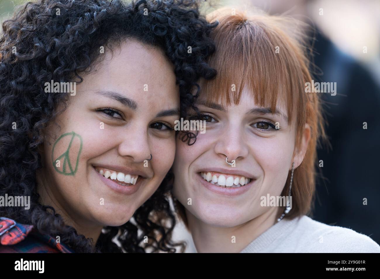 Close-up portrait of two diverse young women friends smiling together ...