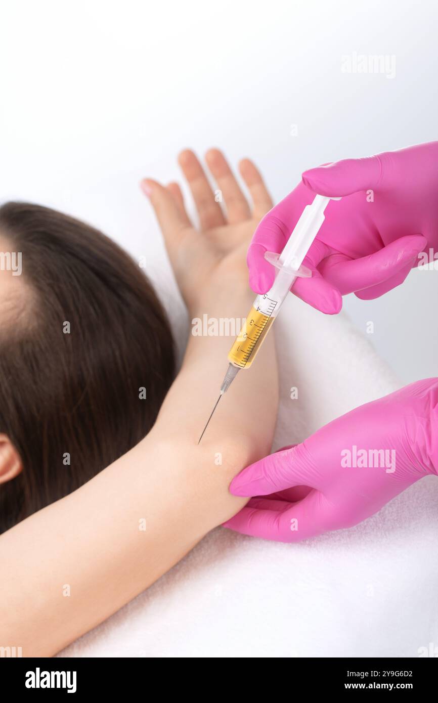 Doctor doing stem cell therapy on a patient's elbow after the injury. Treating knee pain with ...