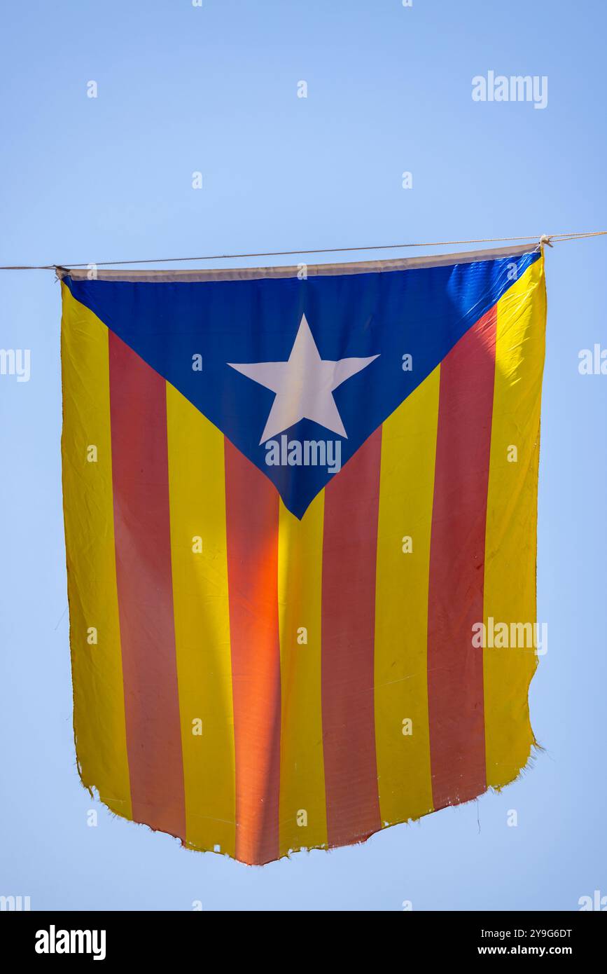Catalan flag hanging between houses Stock Photo - Alamy