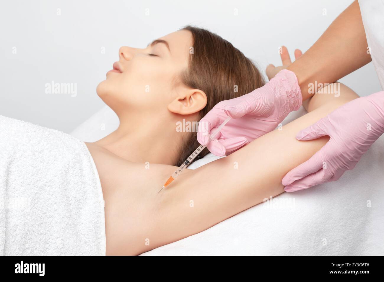 The doctor makes injections of botulinum toxin in the underarm area ...