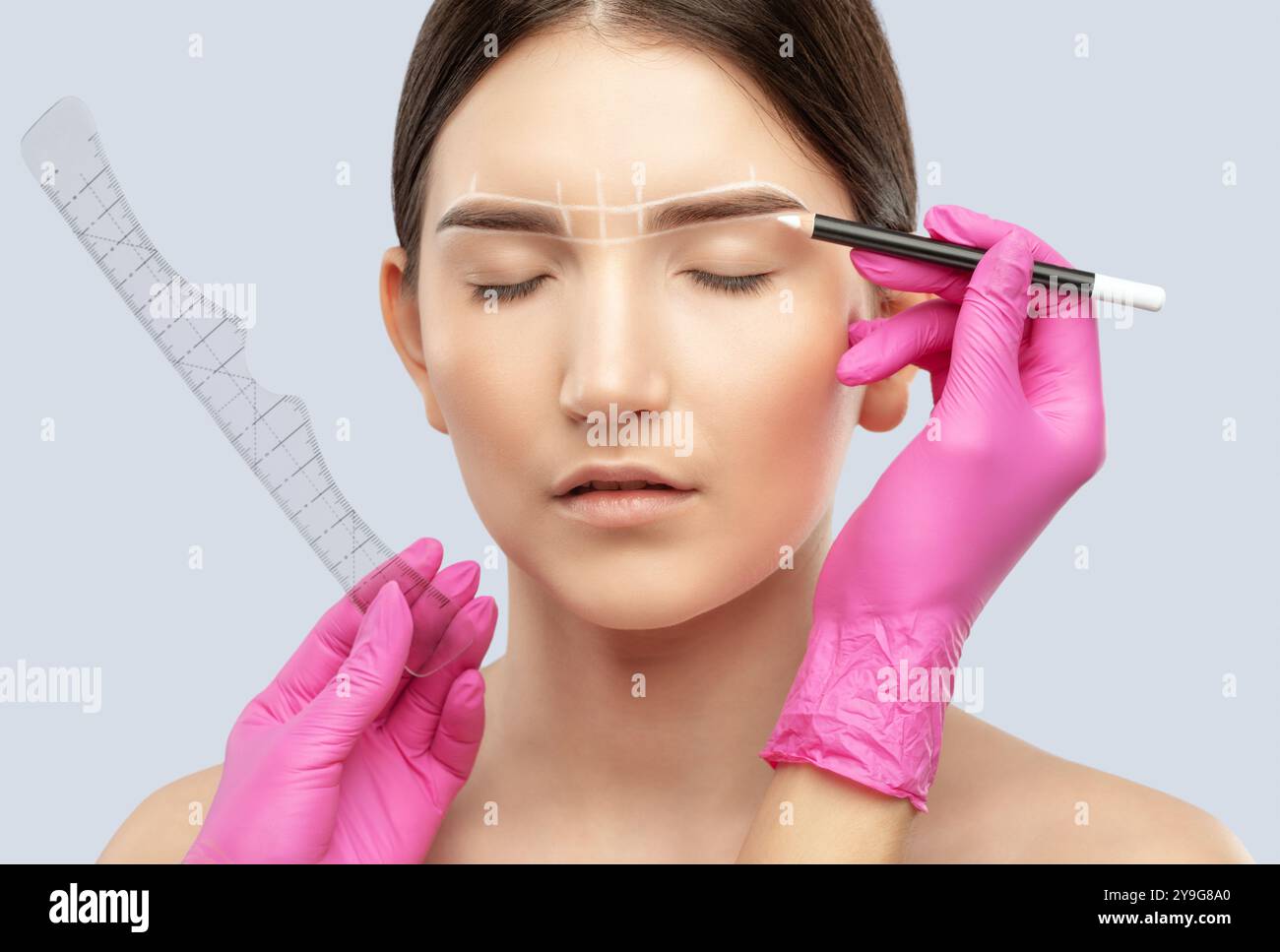 Make-up artist makes markings with white pencil for eyebrow and paints ...