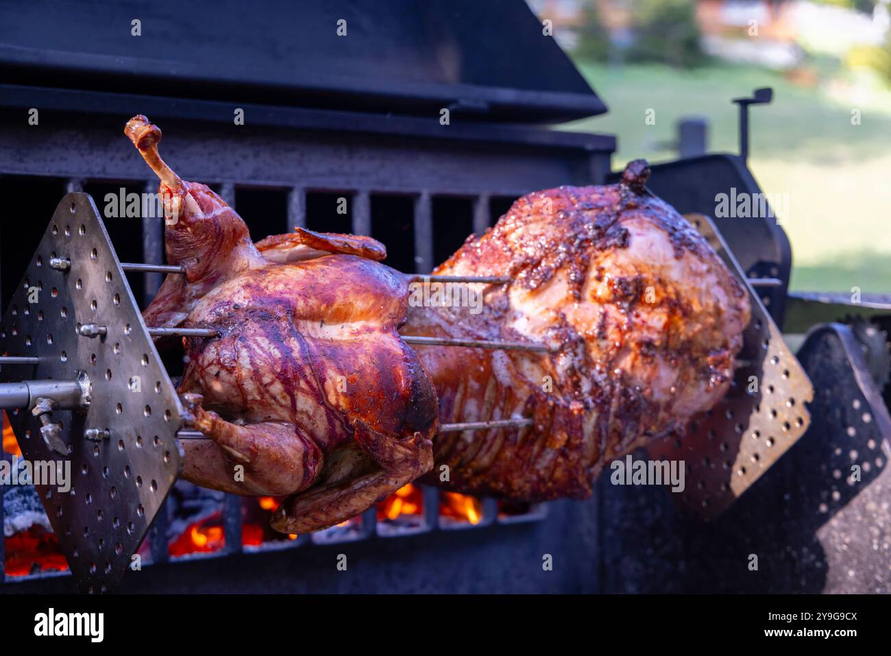 Roasting pork and turkey on spit Stock Photo - Alamy