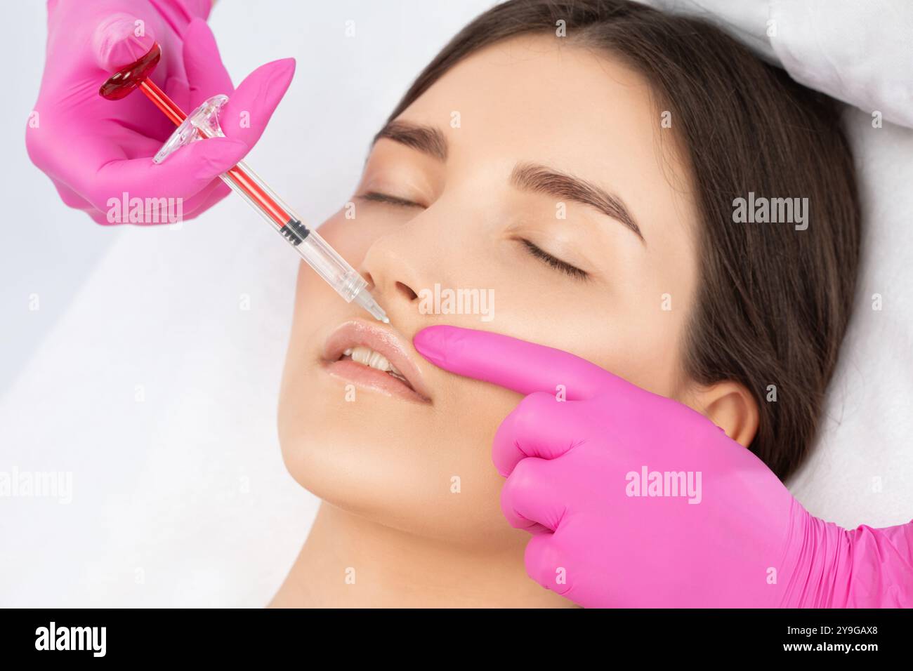 Cosmetologist does injections for lips augmentation and anti wrinkle in ...