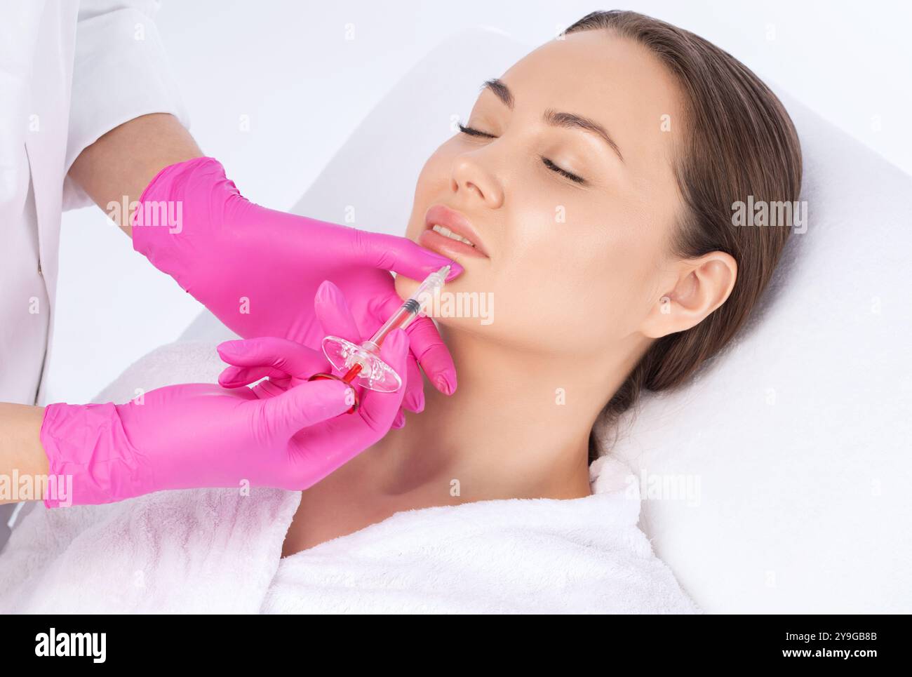 Cosmetologist does injections for lips augmentation and anti wrinkle in ...