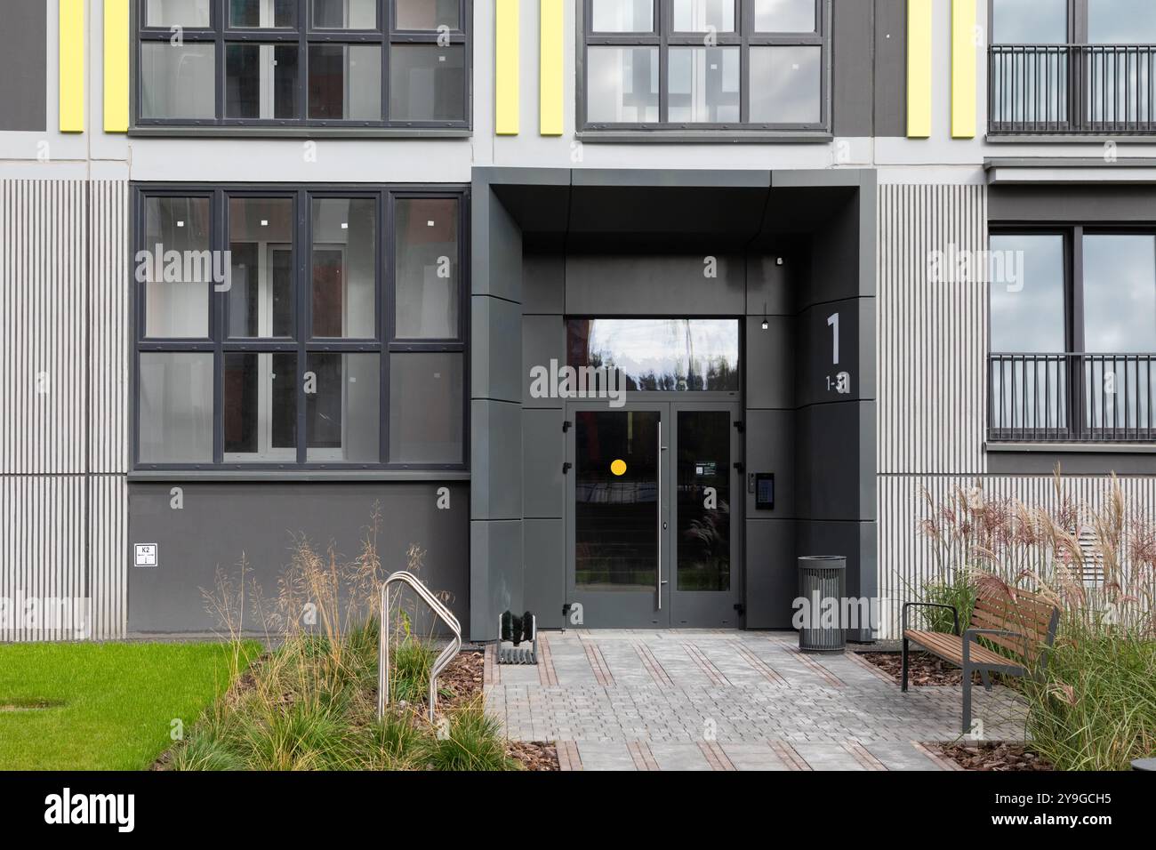 The entrance of a contemporary high-rise apartment building in a lively ...