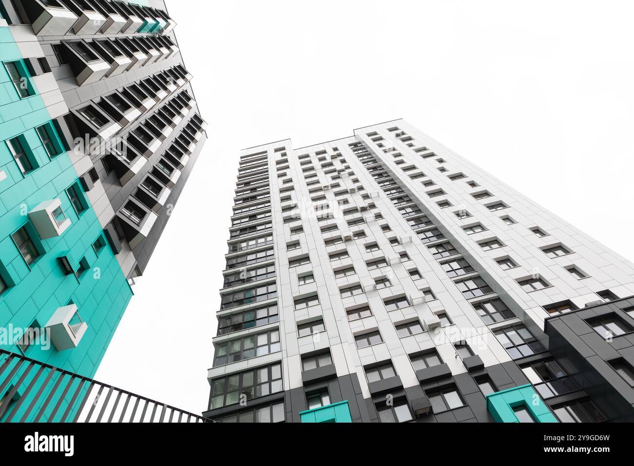 Two tall, contemporary apartment buildings rise prominently in a ...