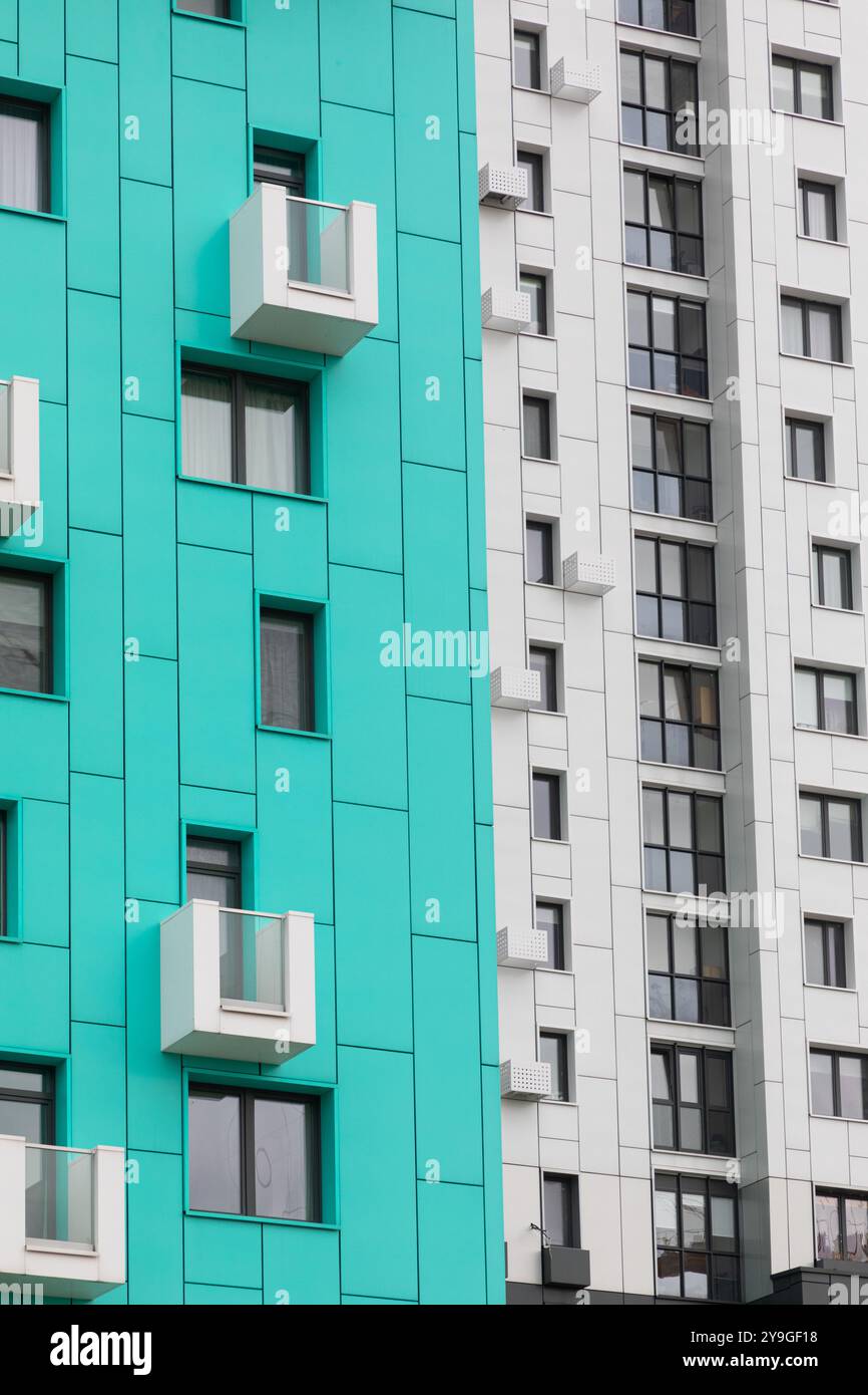 A pair of modern high-rise apartment buildings displays distinct ...