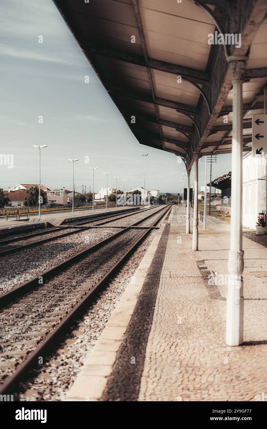 A vertical shot of a deserted train station platform with empty railway ...