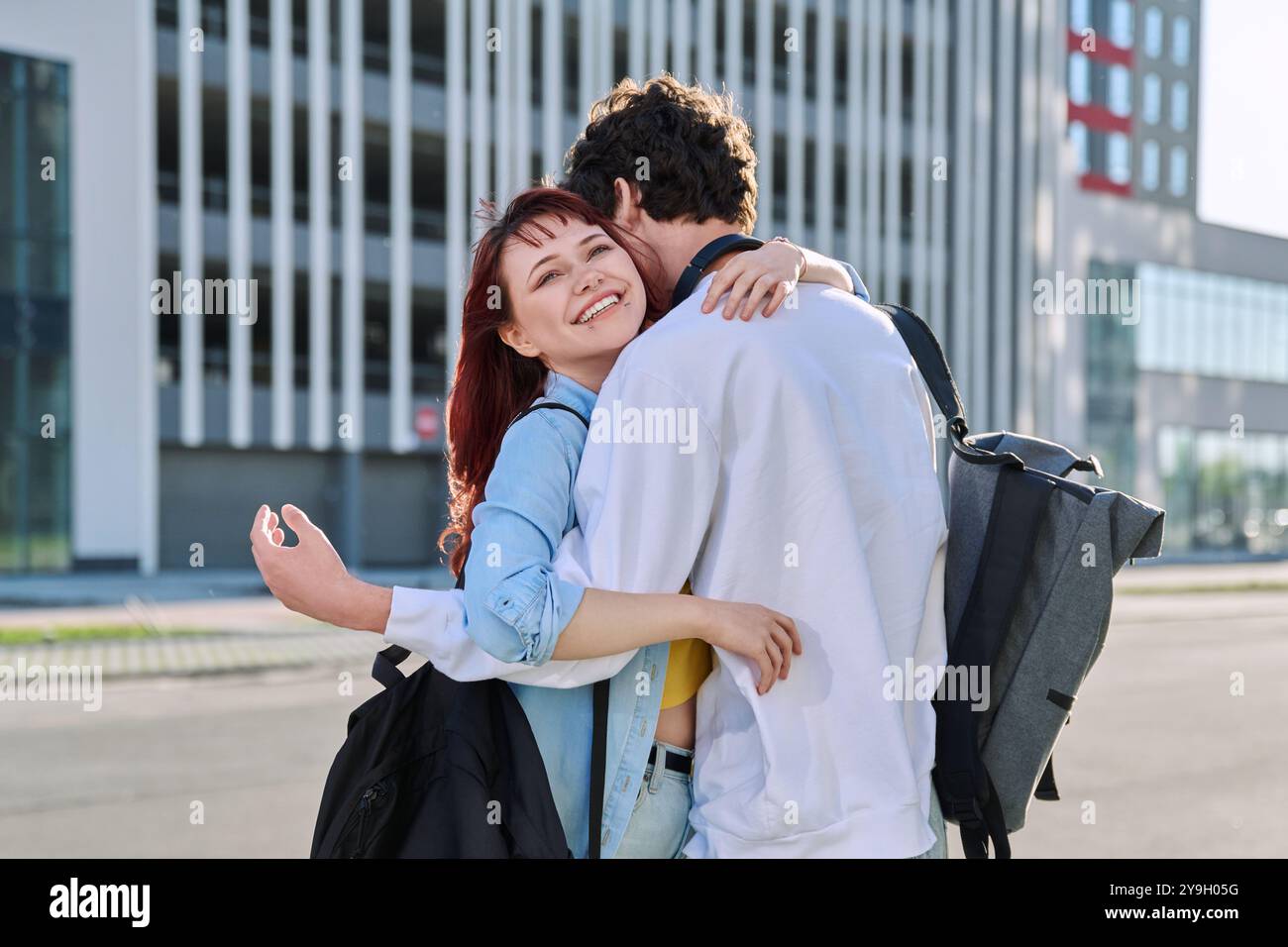 Teenage friends meeting, college students teenage guy and girl hugging ...