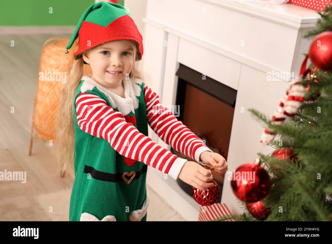 Cute little elf decorating Christmas tree at home Stock Photo - Alamy