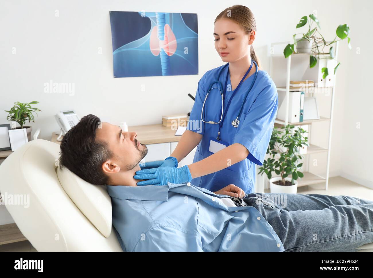 Female endocrinologist examining man's thyroid gland in clinic Stock ...