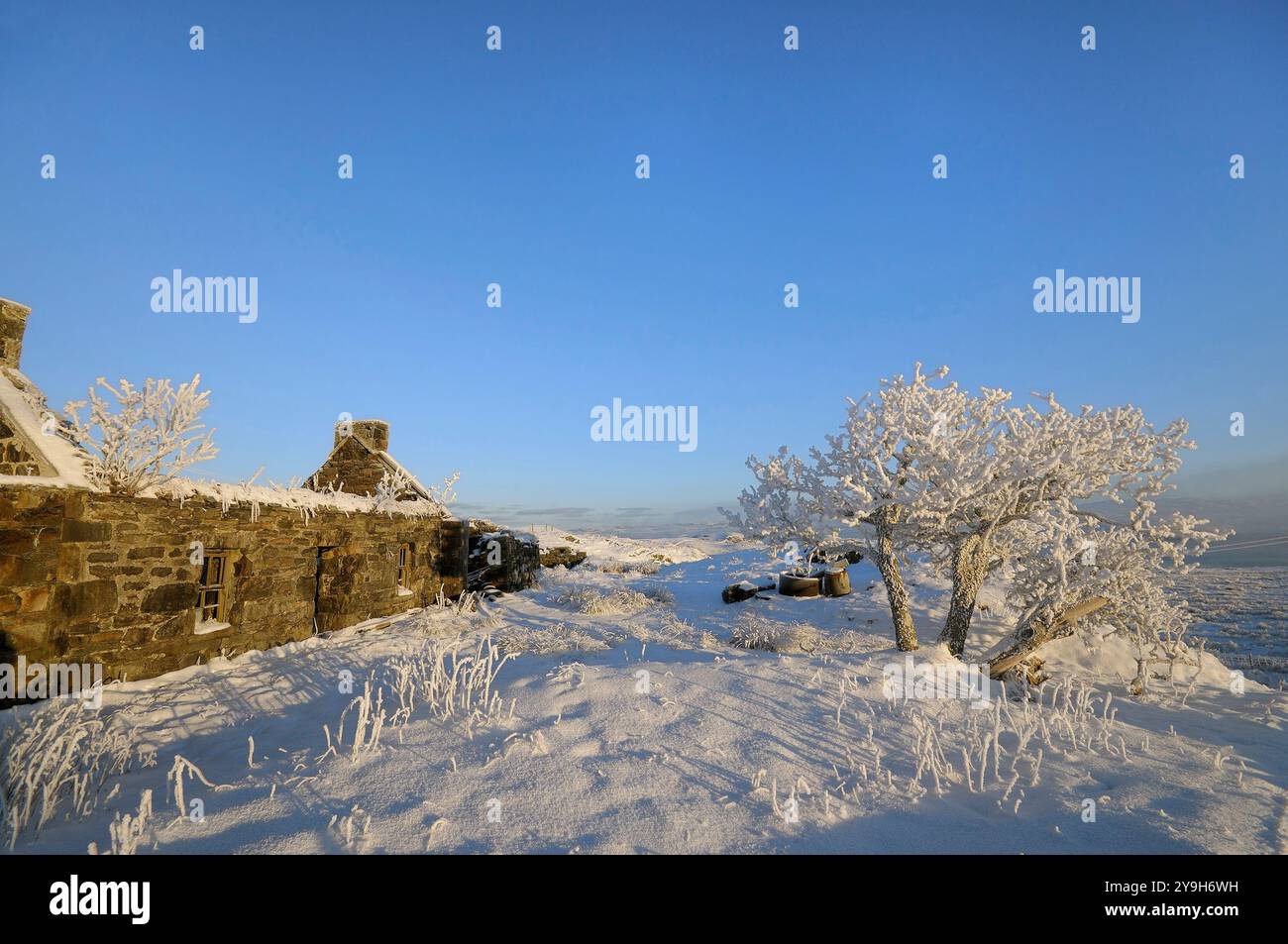 A snow-covered landscape featuring an old stone building and frost ...