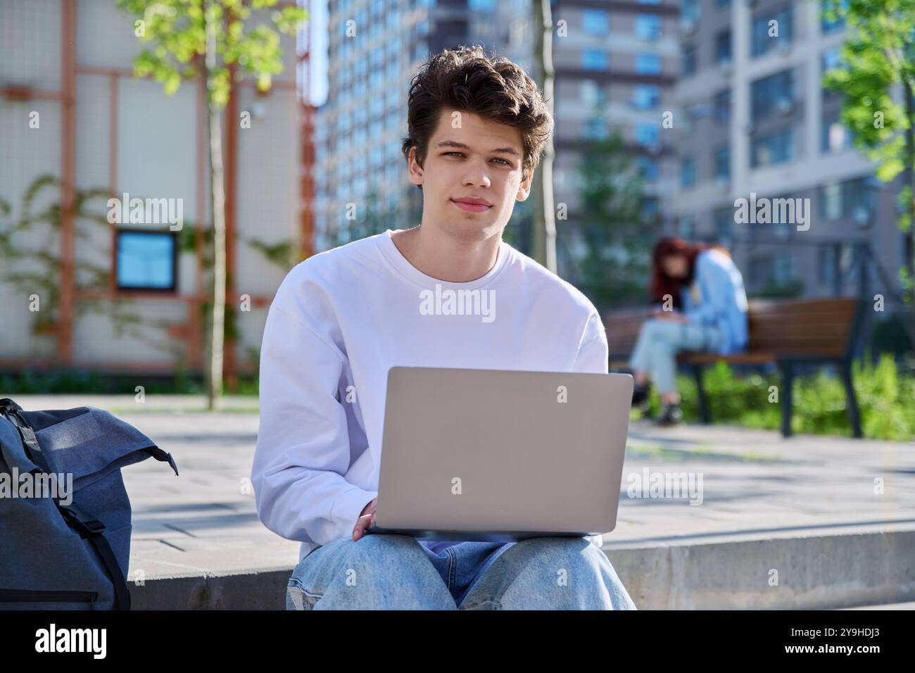 Young guy college student using laptop outdoor Stock Photo - Alamy