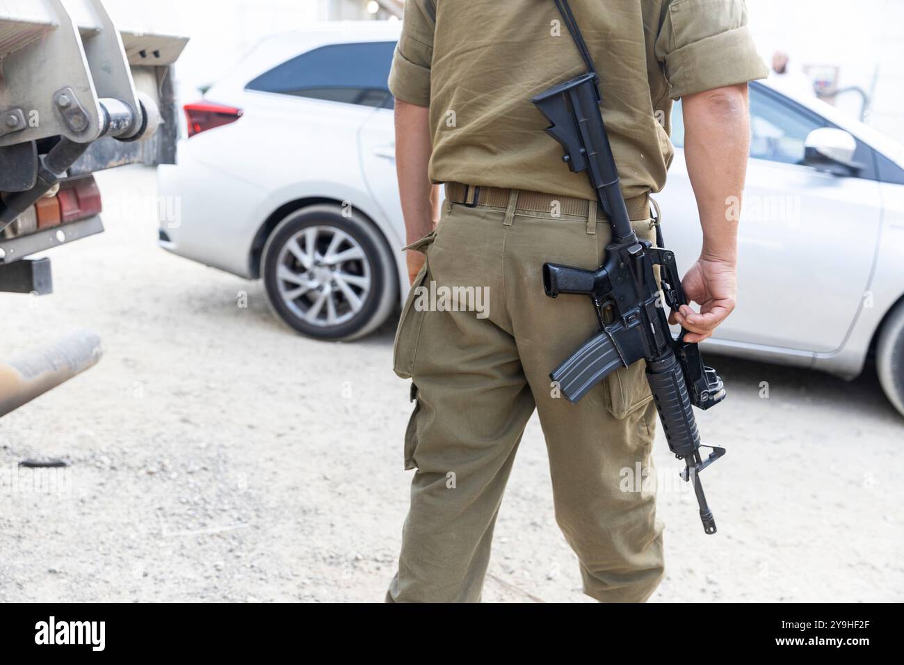 An assault rifle hangs at the side of an unidentified Israeli soldier ...