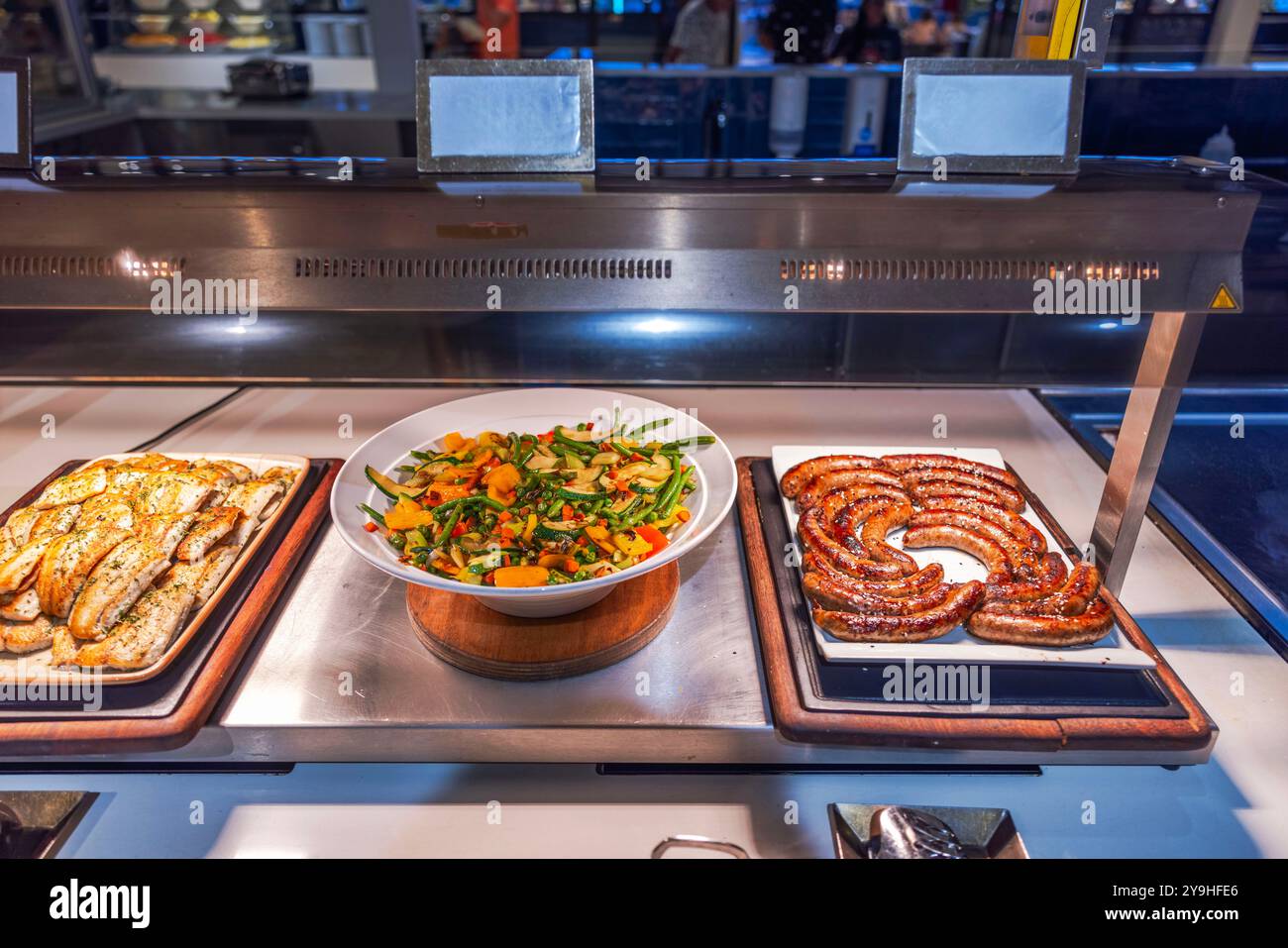 Grilled sausages, roasted vegetables and grilled chicken displayed on ...