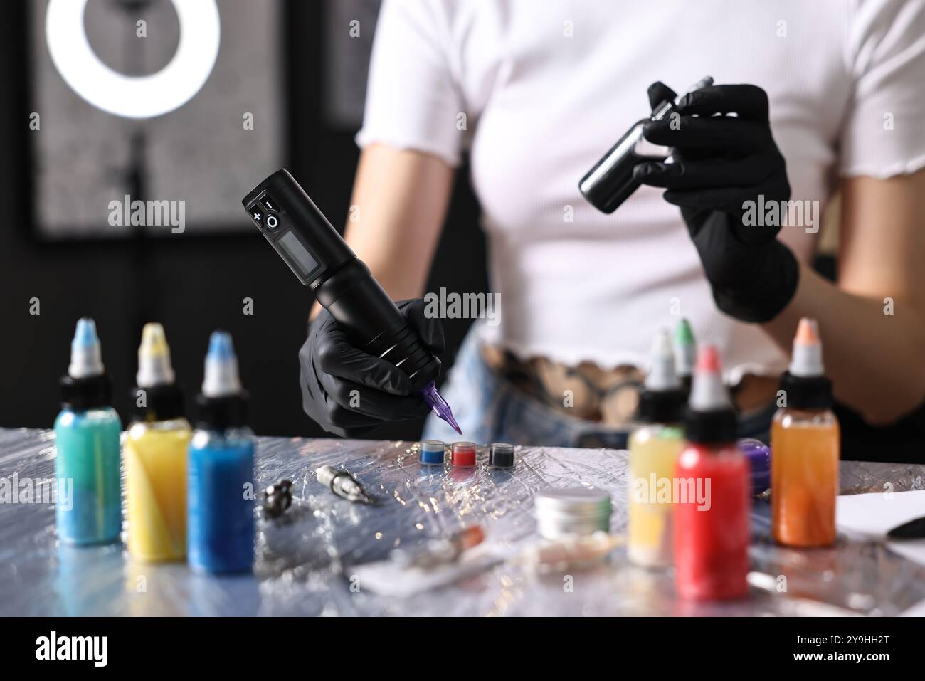 Professional artist working with tattoo machine and inks at sterile ...