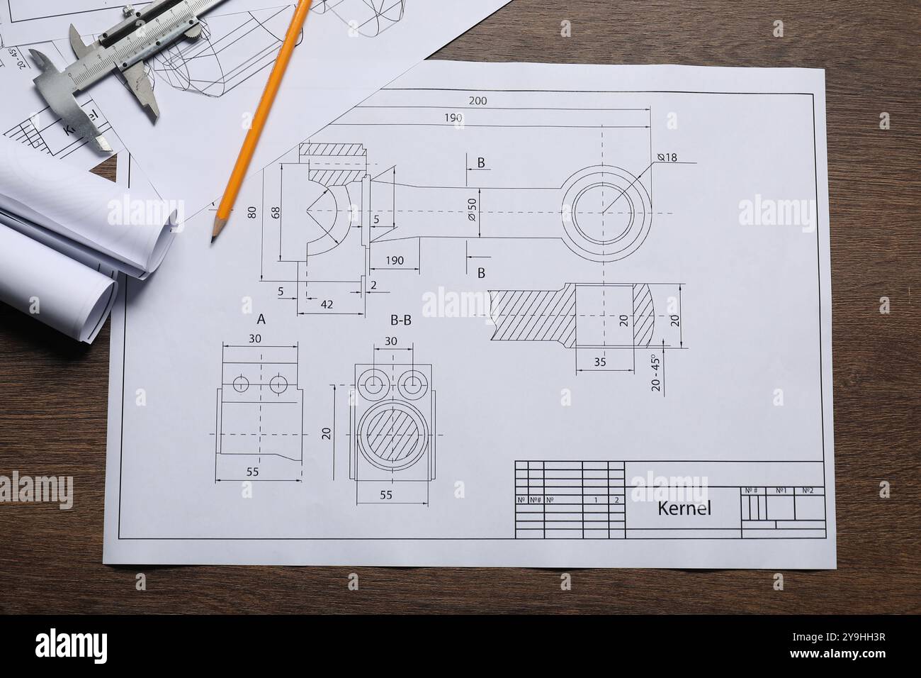 Different engineering drawings, vernier caliper and pencil on wooden ...