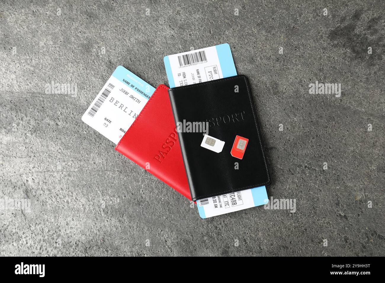 Passports with tickets and SIM cards on grey textured table, flat lay ...