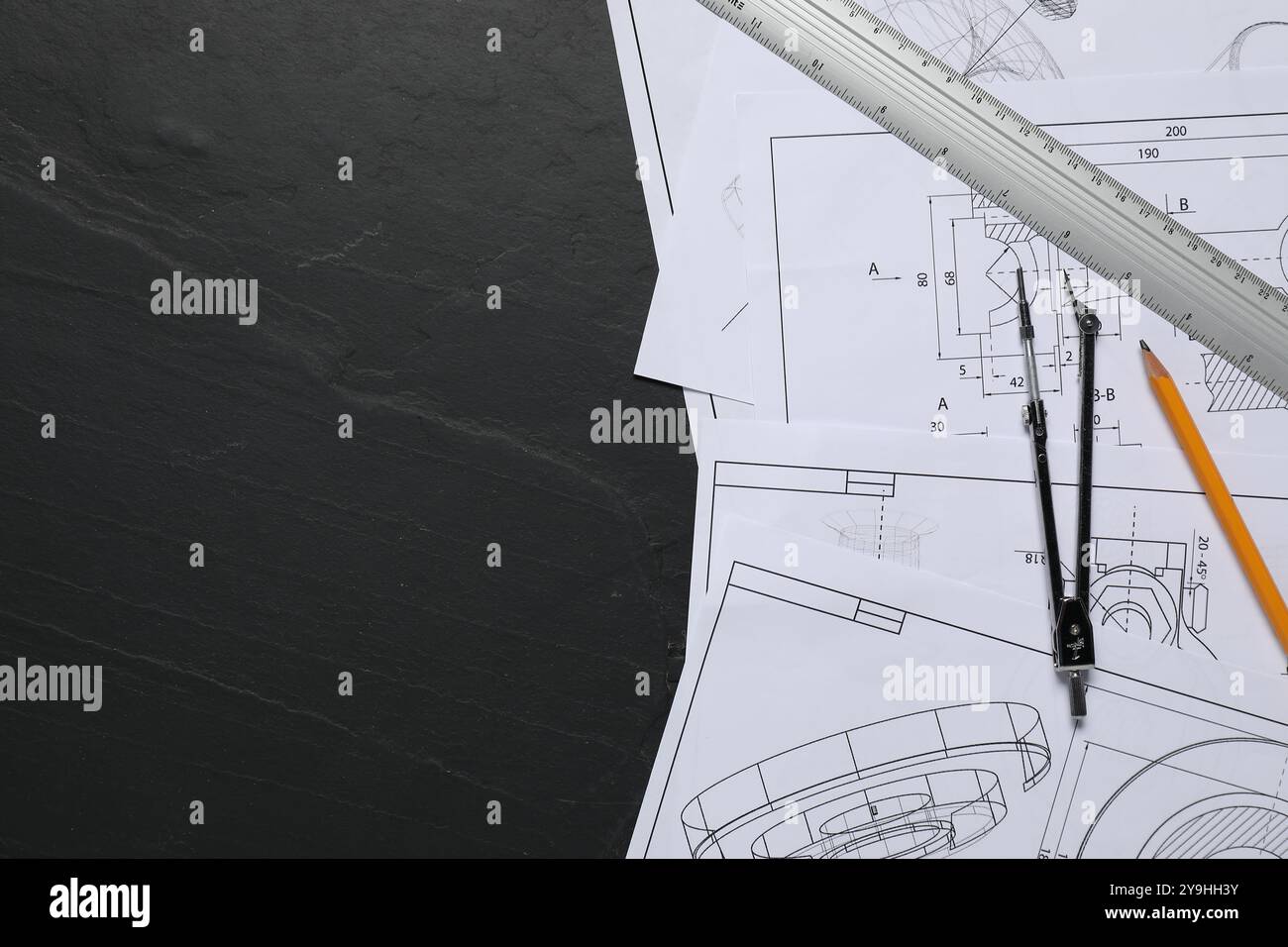 Different engineering drawings, pencil, ruler and divider on grey ...