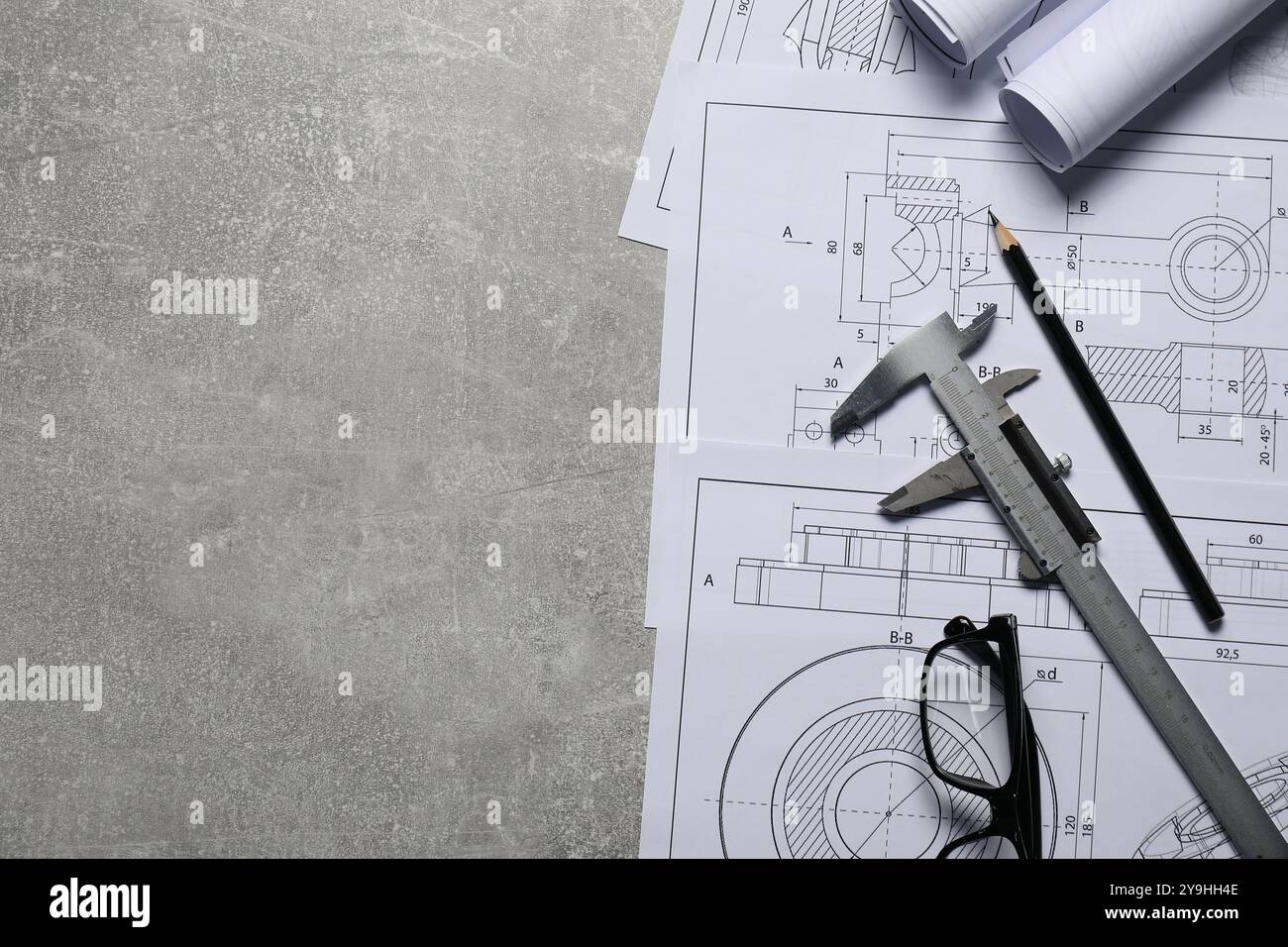 Different engineering drawings, vernier caliper, pencil and glasses on ...