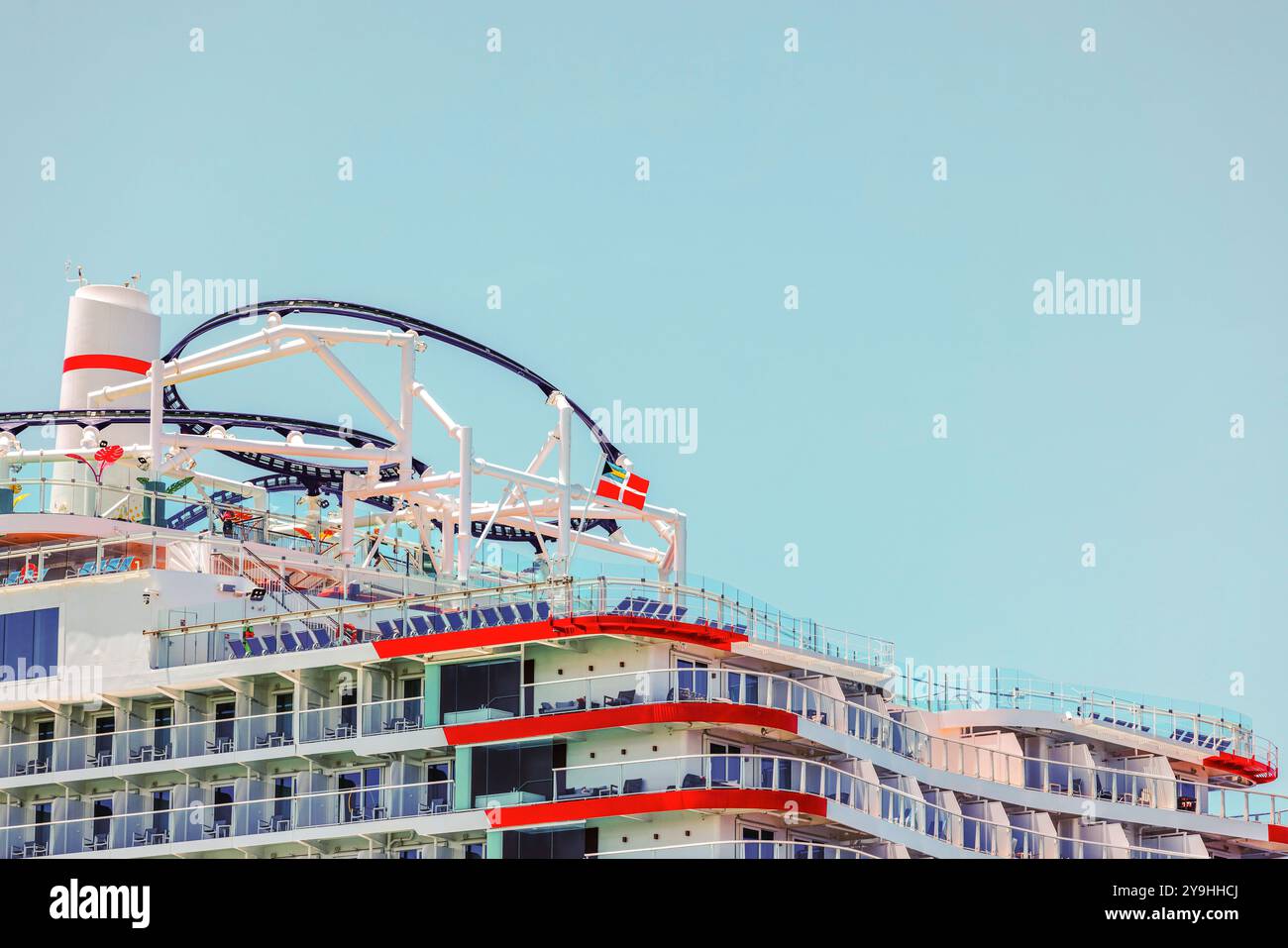 Roller coaster ride on top of cruise ship deck under clear blue sky in ...