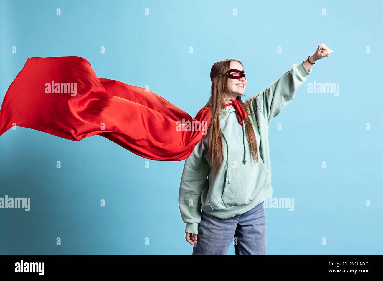 Cheerful girl wearing superhero costume and mask for Halloween with ...